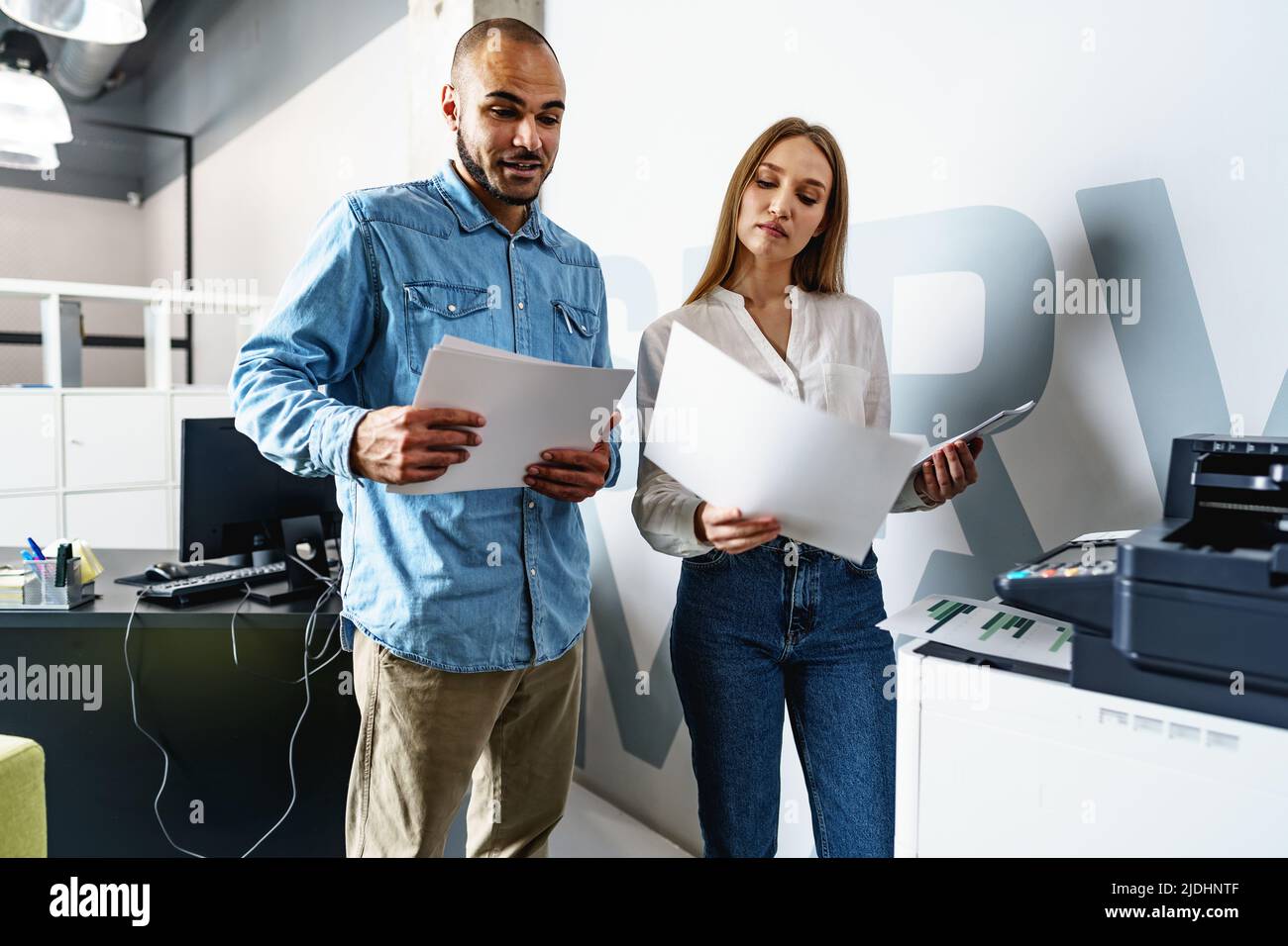 Two employees using new modern printer in office Stock Photo - Alamy