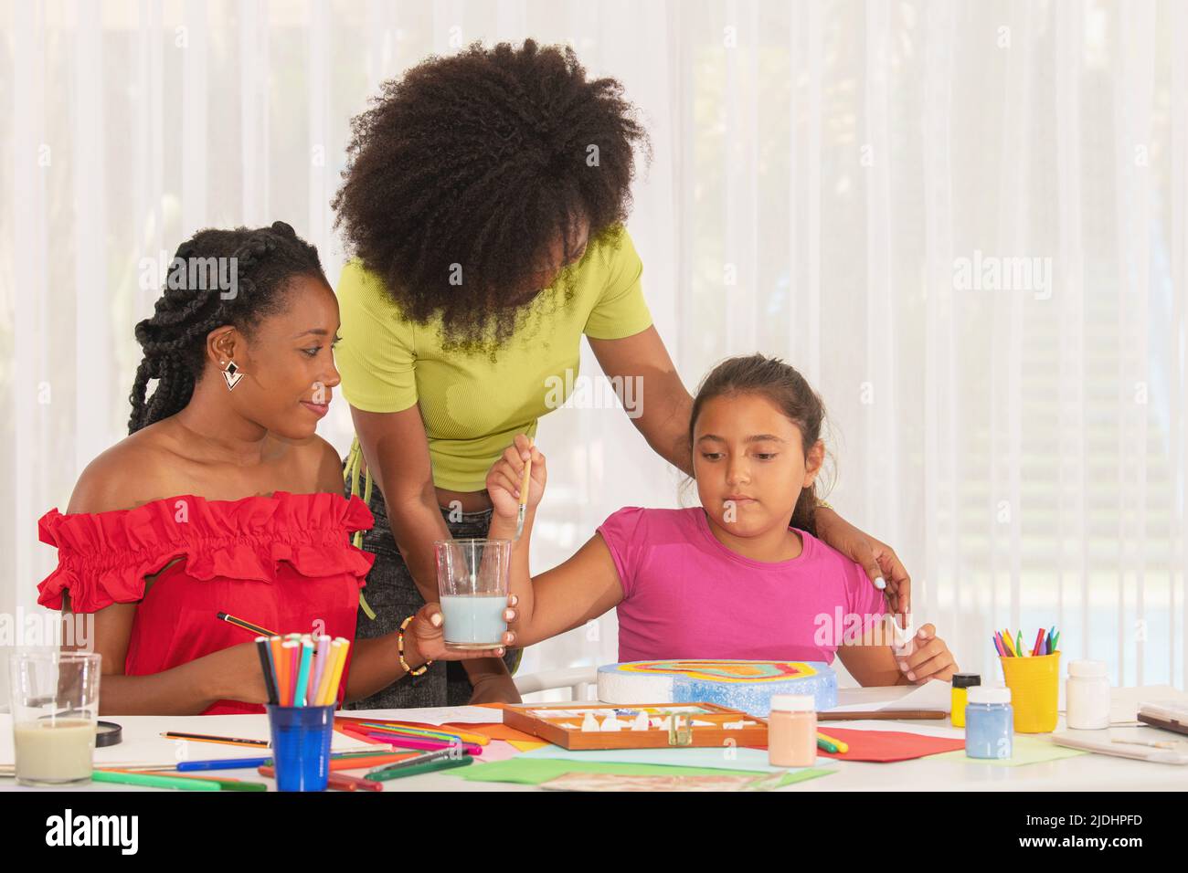 Two teachers helping to student girl to painting in art class Stock ...