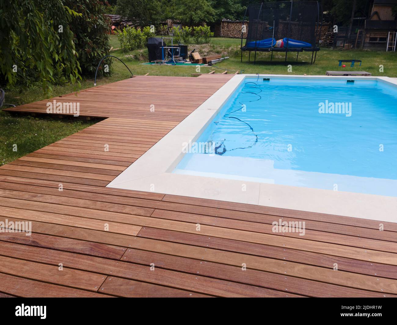 aerial drone flight over beautiful green garden with pool and the ...