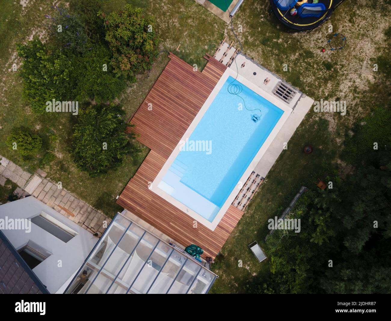 aerial drone flight over beautiful green garden with pool and the ...