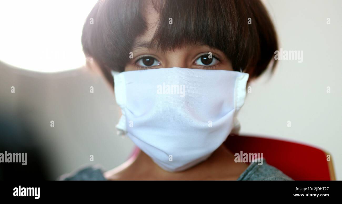 Young boy putting pandemic mask prevention on face, kid wearing ...