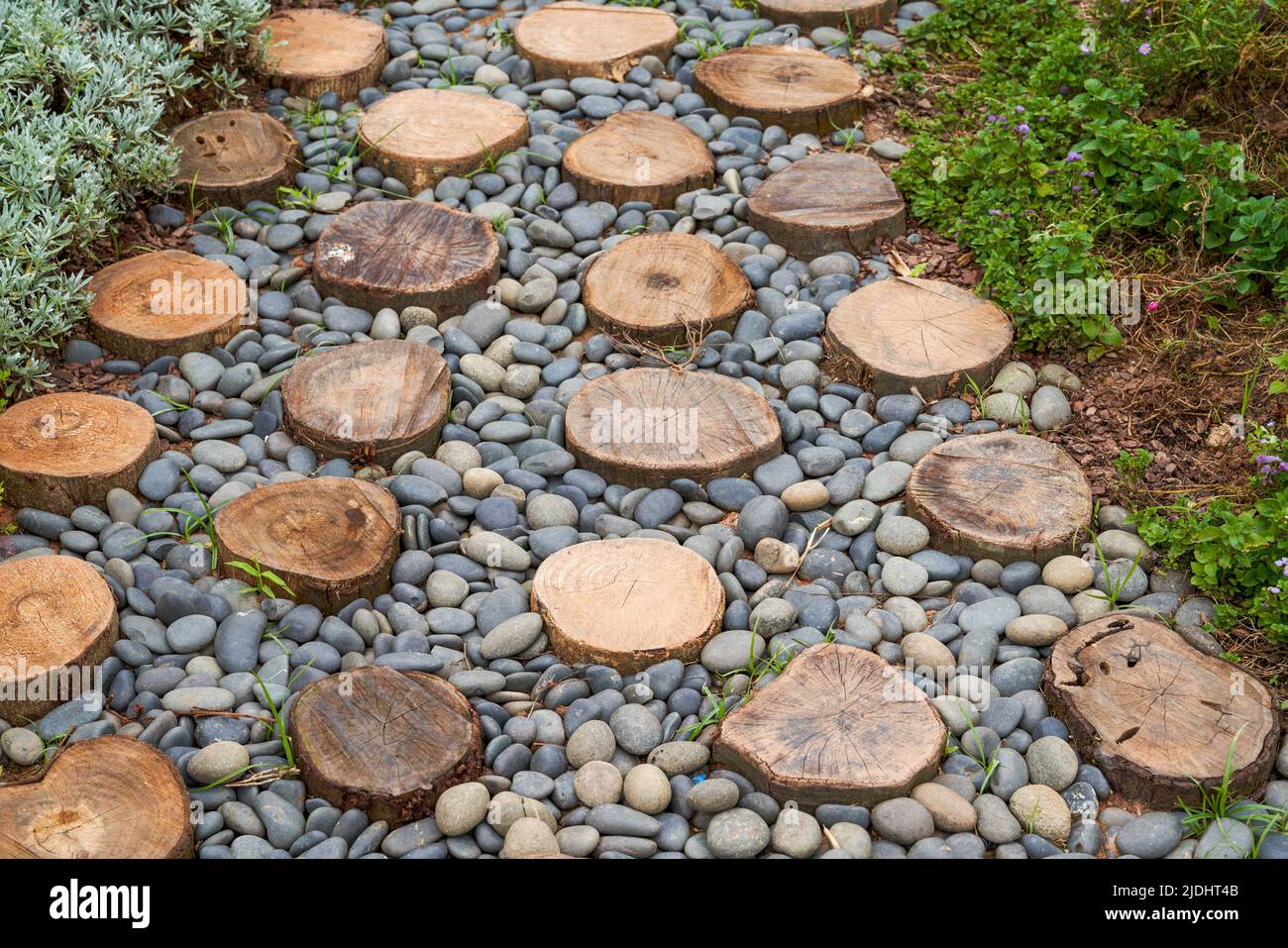 Walkway made of logs and pebbles in a landscaped garden Stock Photo - Alamy