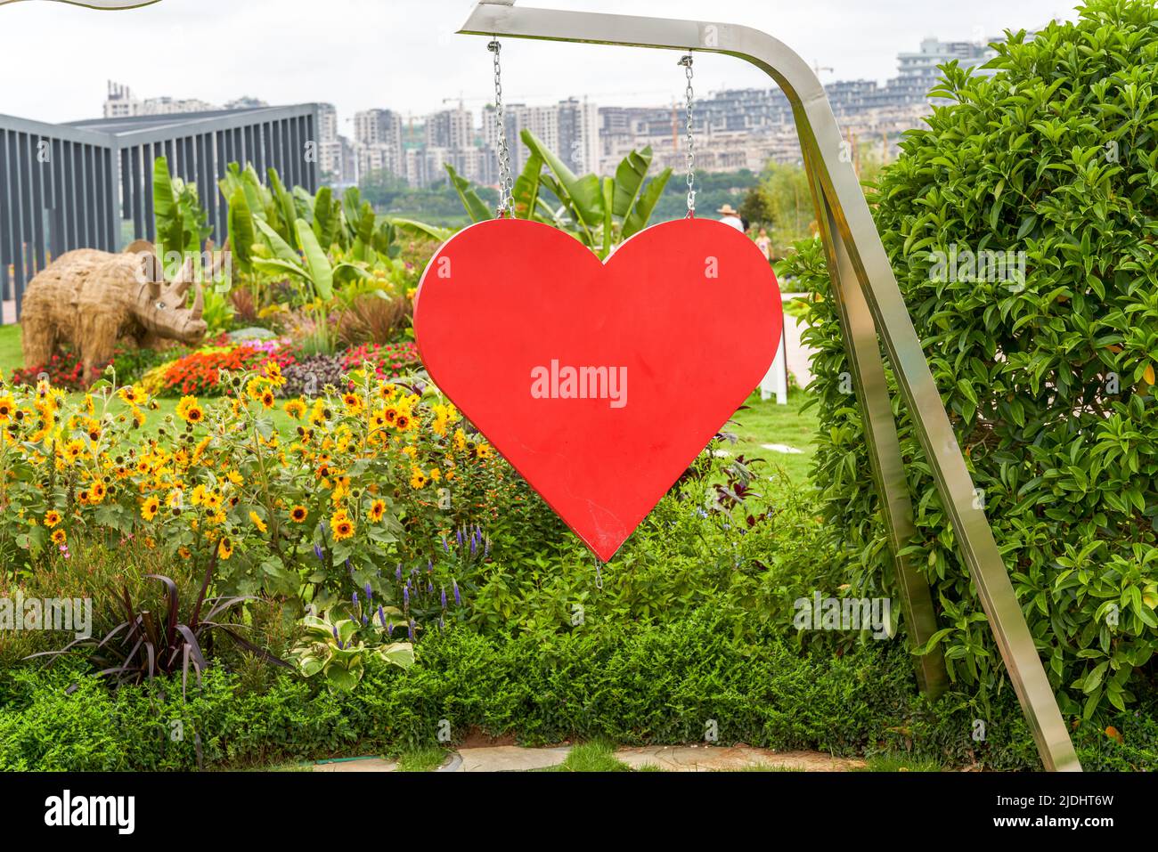 Big red heart hanging from an iron frame in the park Stock Photo - Alamy
