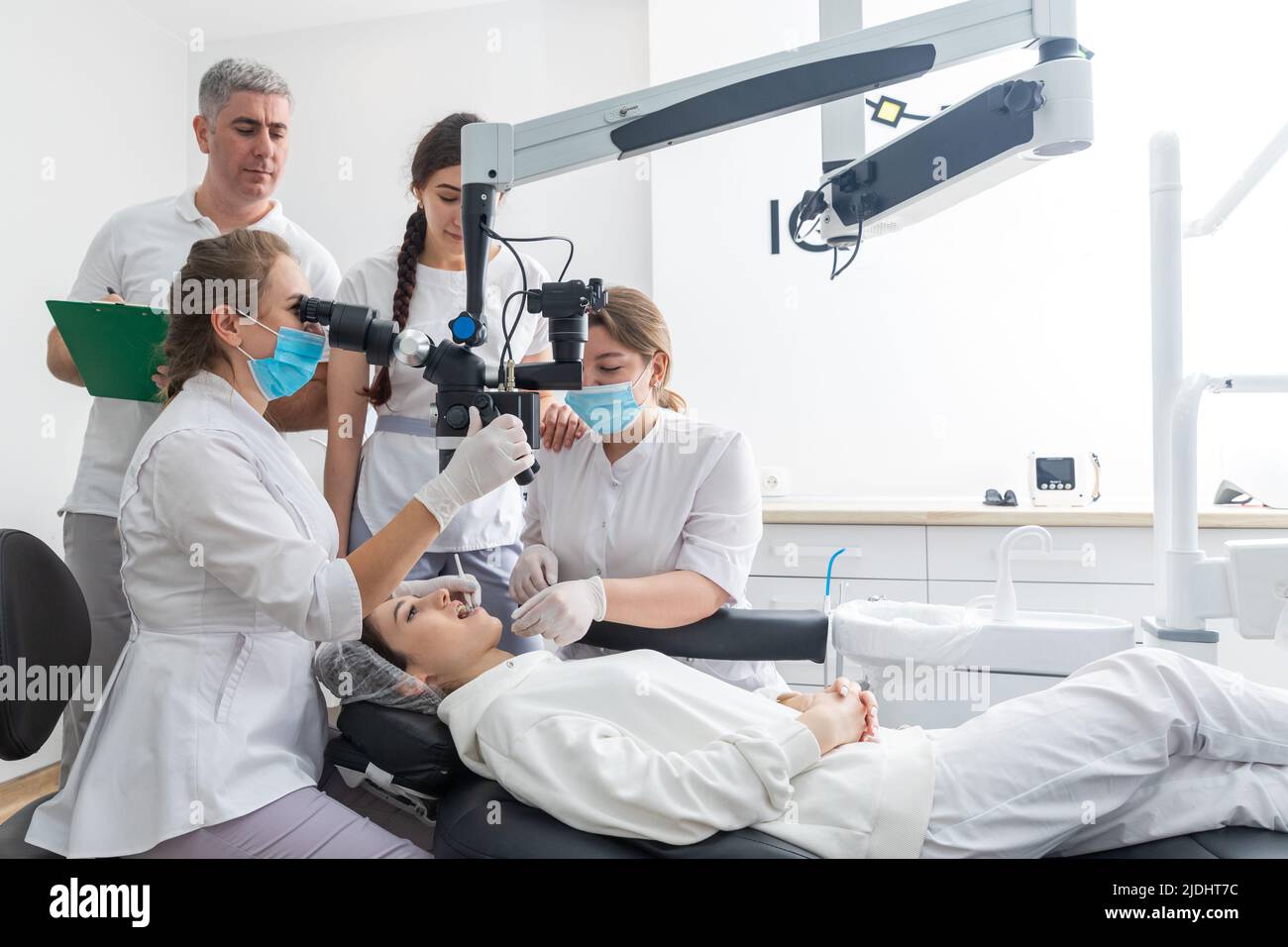 Group of young doctors learning in dental clinic watching dental ...