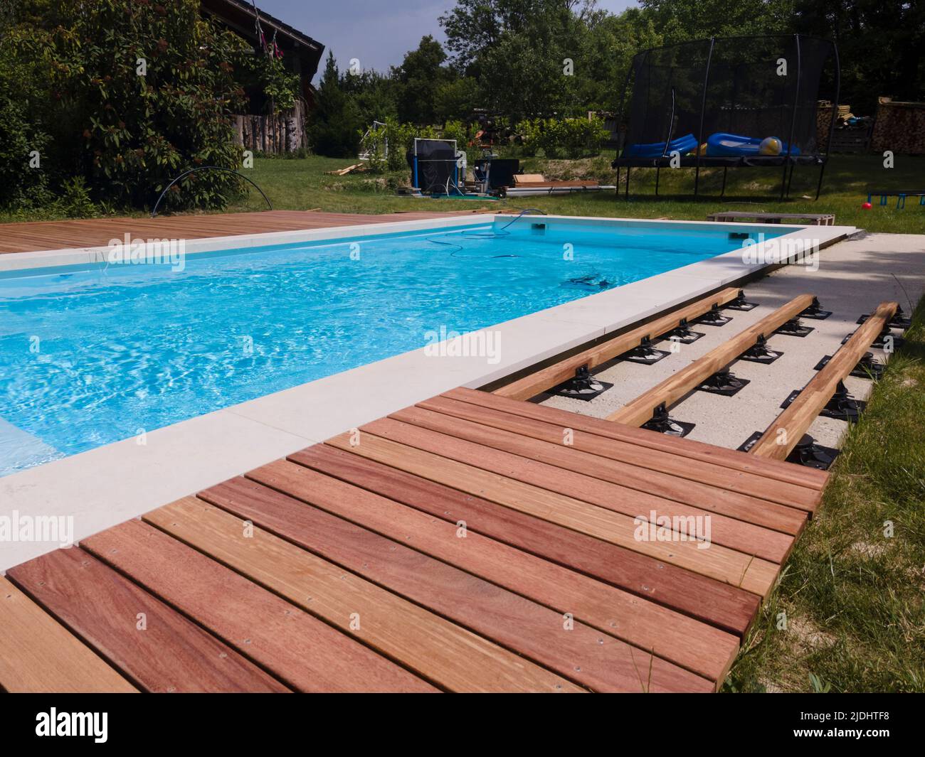 aerial drone flight over beautiful green garden with pool and the ...