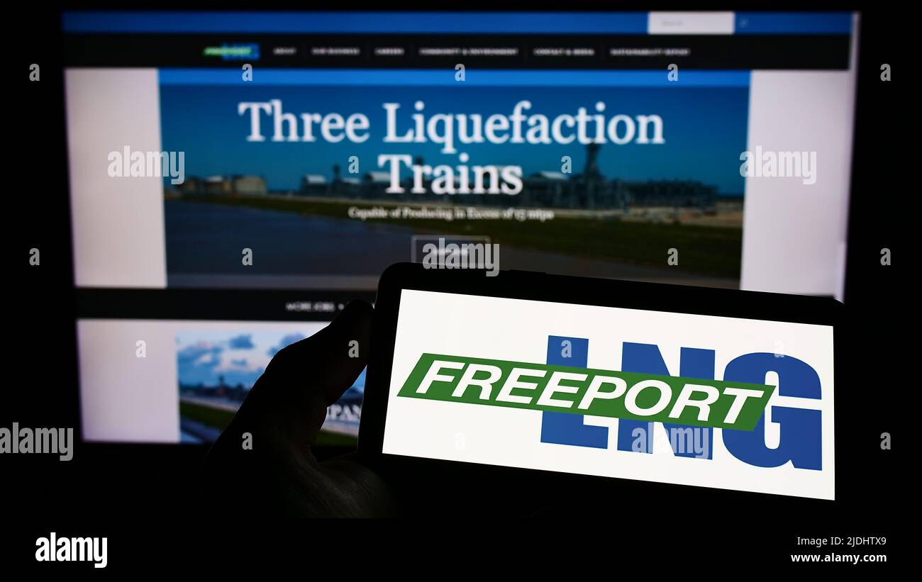 Person holding smartphone with logo of US gas company Freeport LNG ...