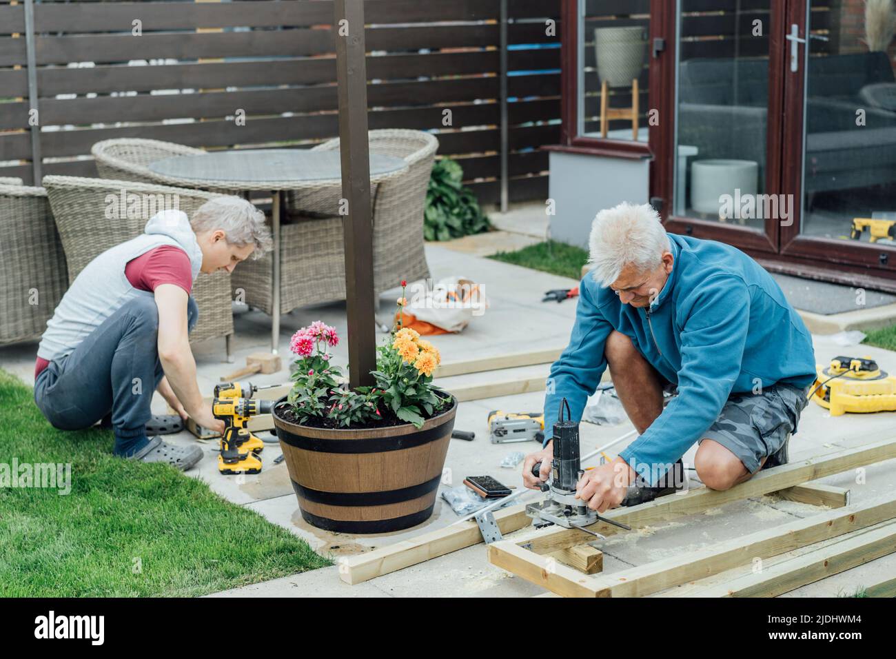 Adult son and father carpenter working together, handle wooden timbers ...