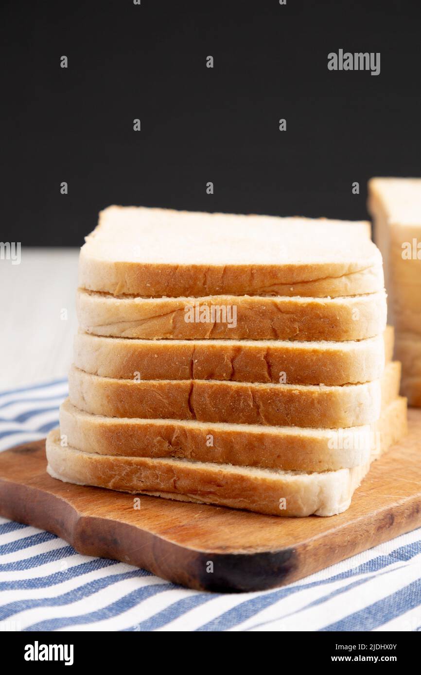 Slices of White Bread on a Rustic Wooden Board, side view Stock Photo ...