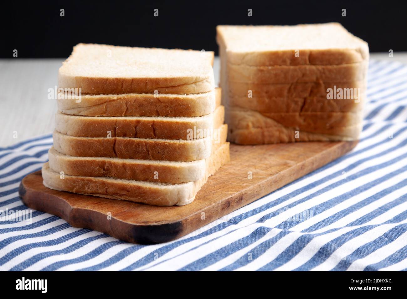 Slices of White Bread on a Rustic Wooden Board, side view Stock Photo ...