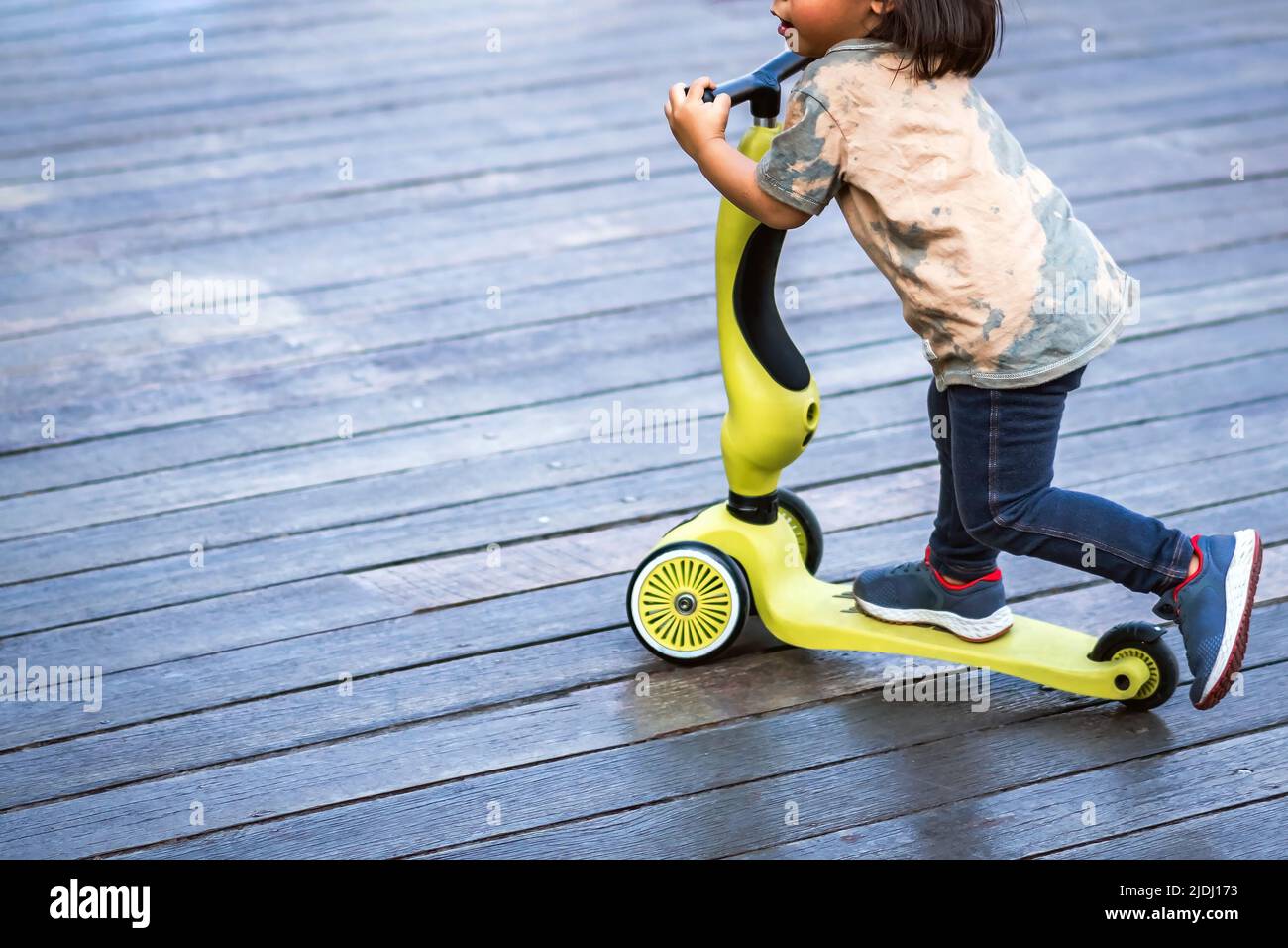 Asian kid enjoy playing and riding scooter without using any safety ...
