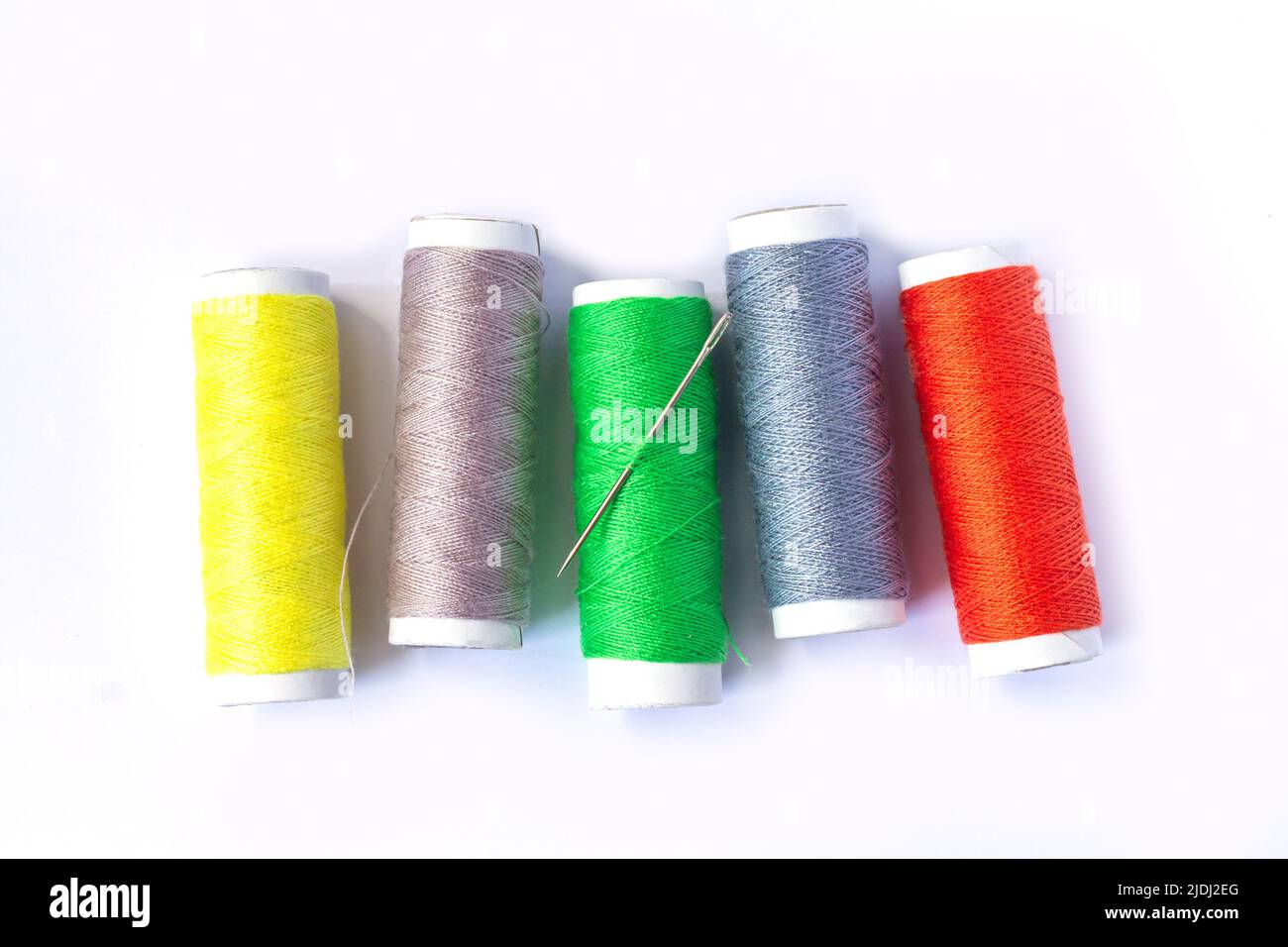 Set of colorful spools of sewing threads with needle, seamstress tools ...