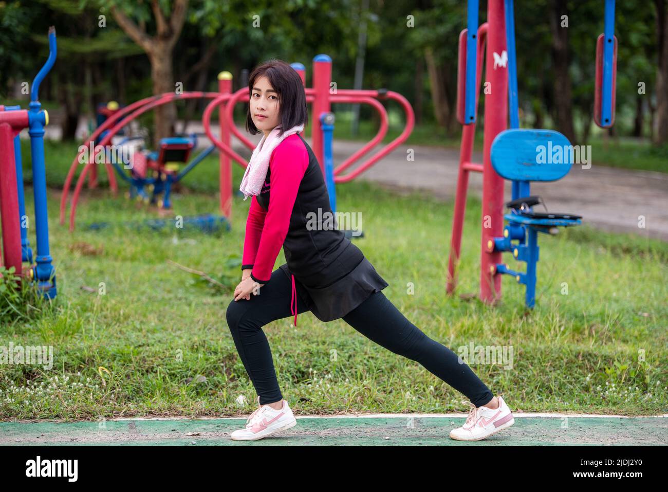 Young woman stretching muscle before running Stock Photo - Alamy