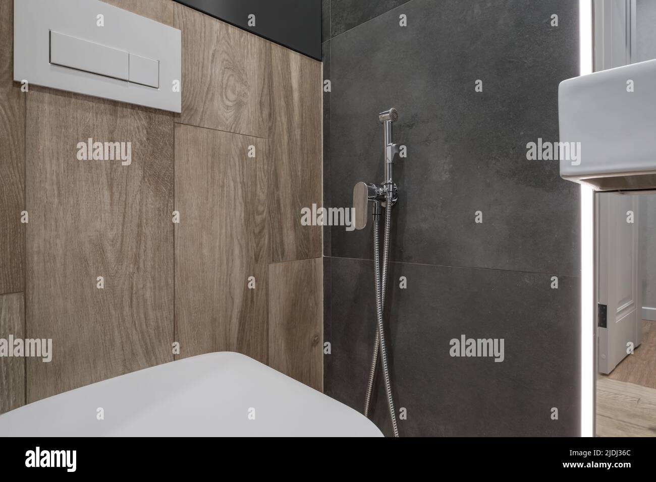 toilet and detail of a corner shower cabin with wall mount shower ...