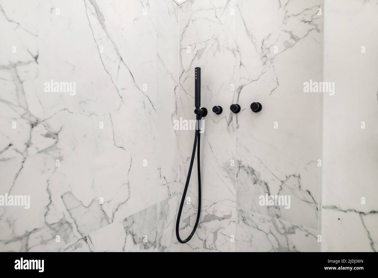 toilet and detail of a corner shower cabin with wall mount shower ...