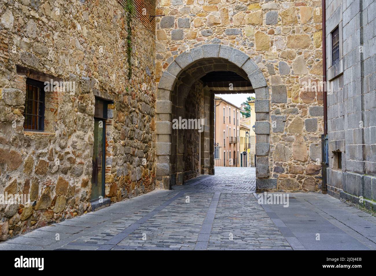 Pedestrian alley in medieval town with stone arch under old building ...