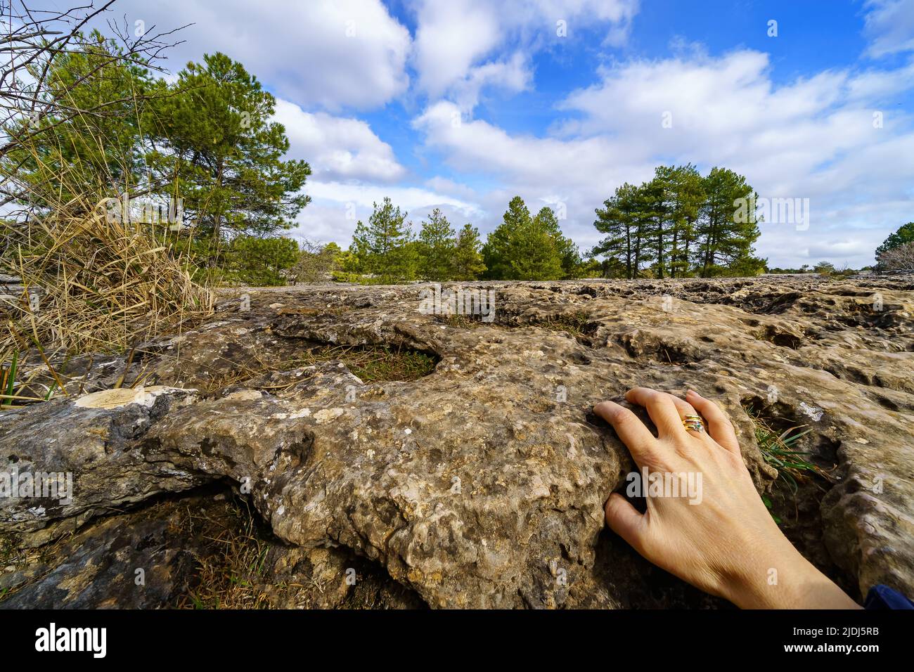 Woman's hand touching the large stones on the ground in a strange ...