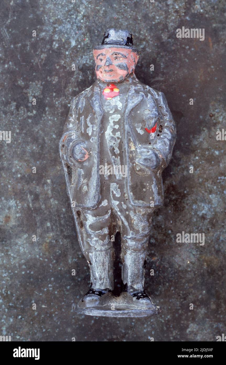 Worn lead model of rotund 19th century farmer standing against mottled ...
