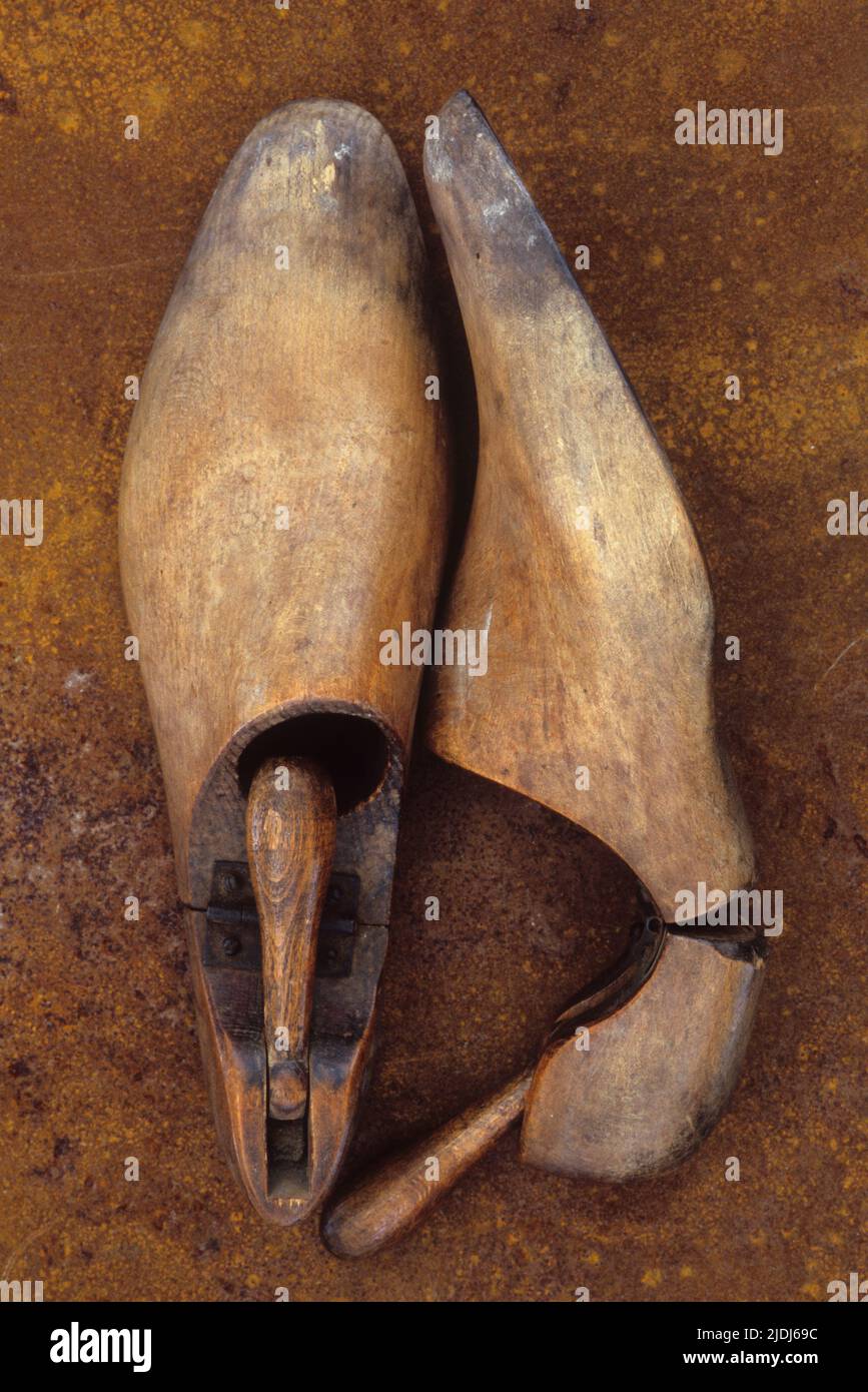 Old well-used wooden shoe trees or stretchers lying on rusty metal ...