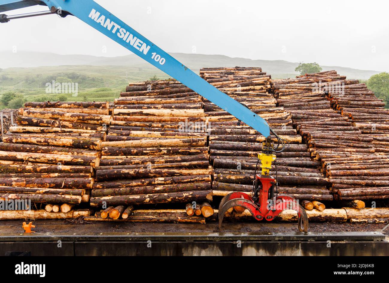 A large blue Mantsinen 100 RHC hydraulic mechanical grabber by stacked ...