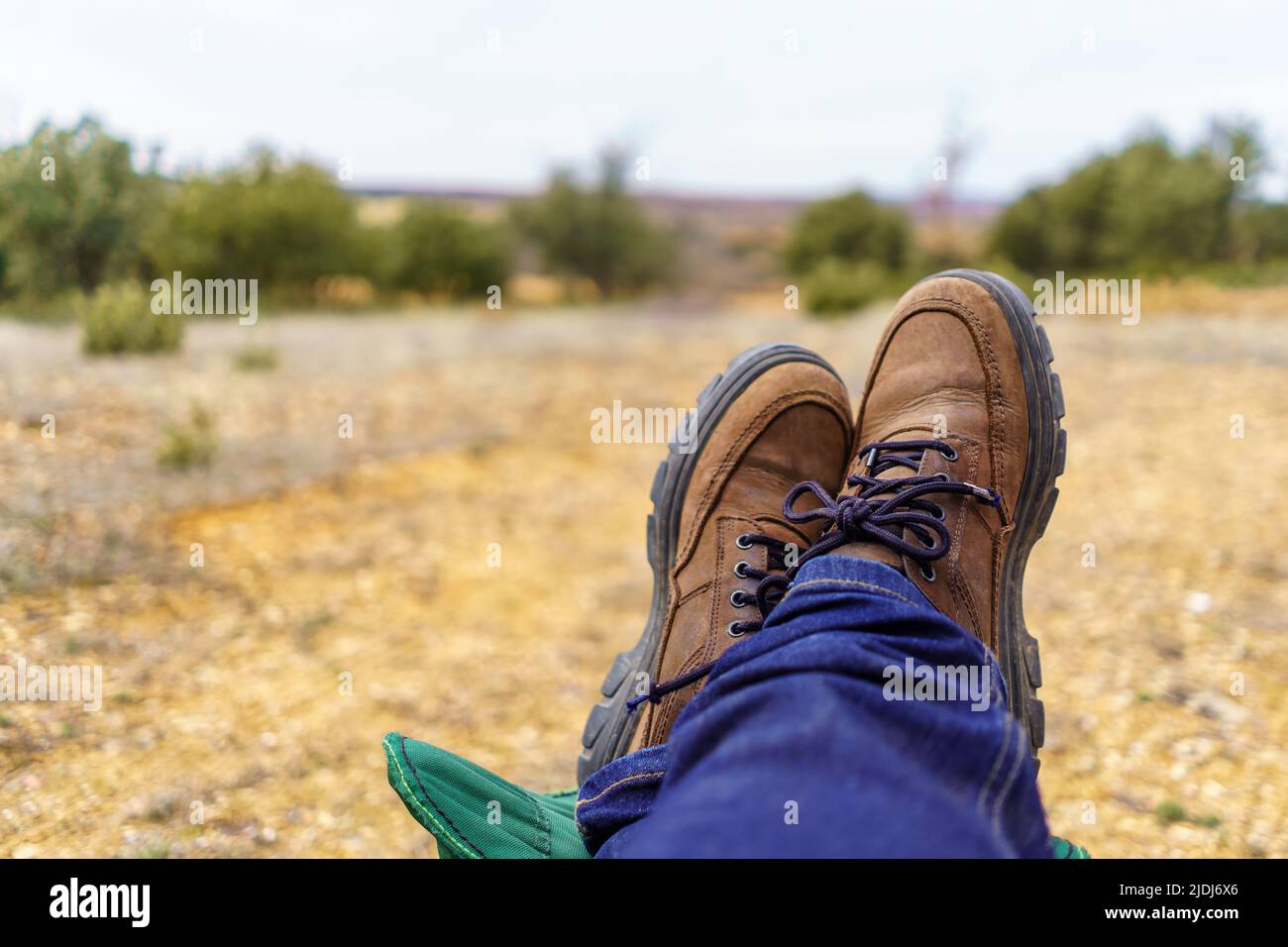 Man resting his feet on a footrest in the field in a relaxed way Stock ...