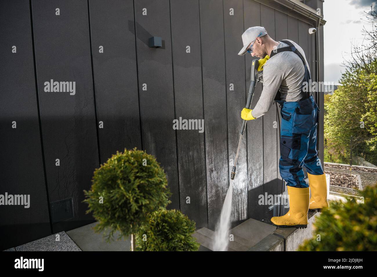 Male Caucasian Home Owner at His 40s Wearing His Work Clothes Cleaning ...
