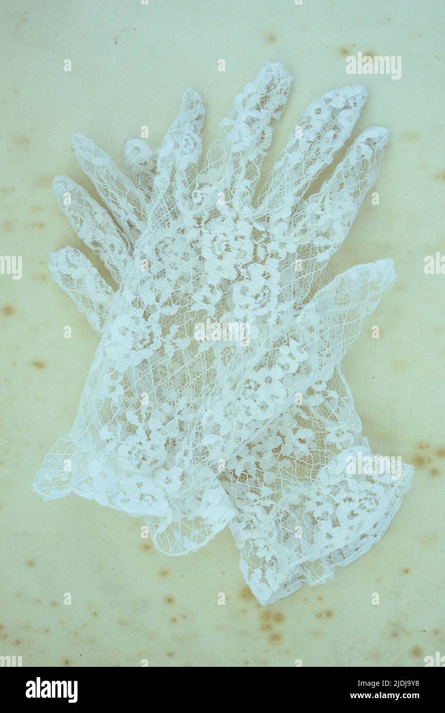 Pair of ladies or girls white lacy see-through gloves lying on antique ...