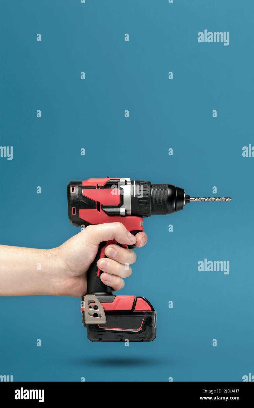 Cordless screwdriver in hand. Cordless tool in a man's hand. The ...