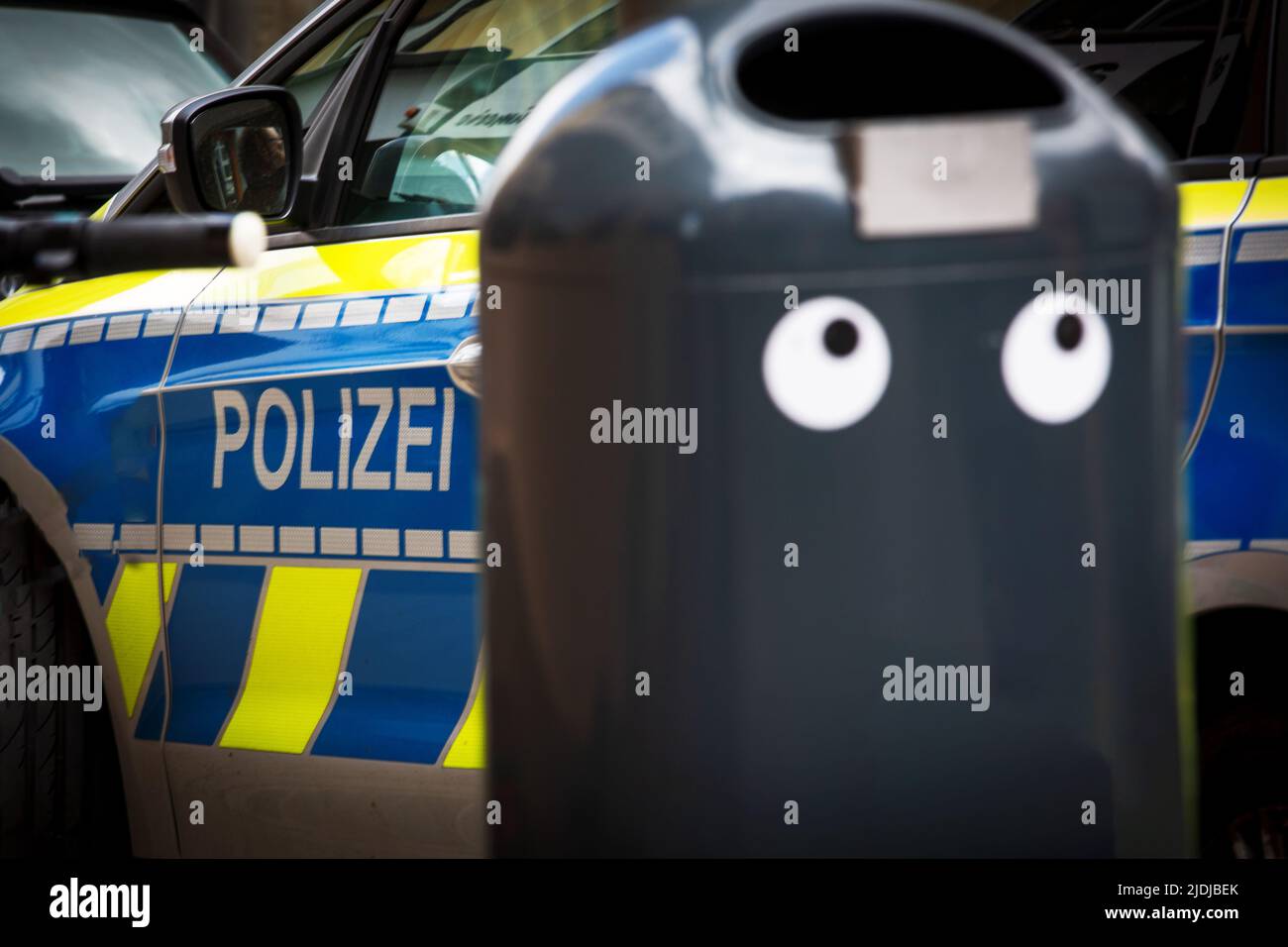 Litter Garbage Can With Eyes In Front Of Police Patrol Car Stock Photo ...