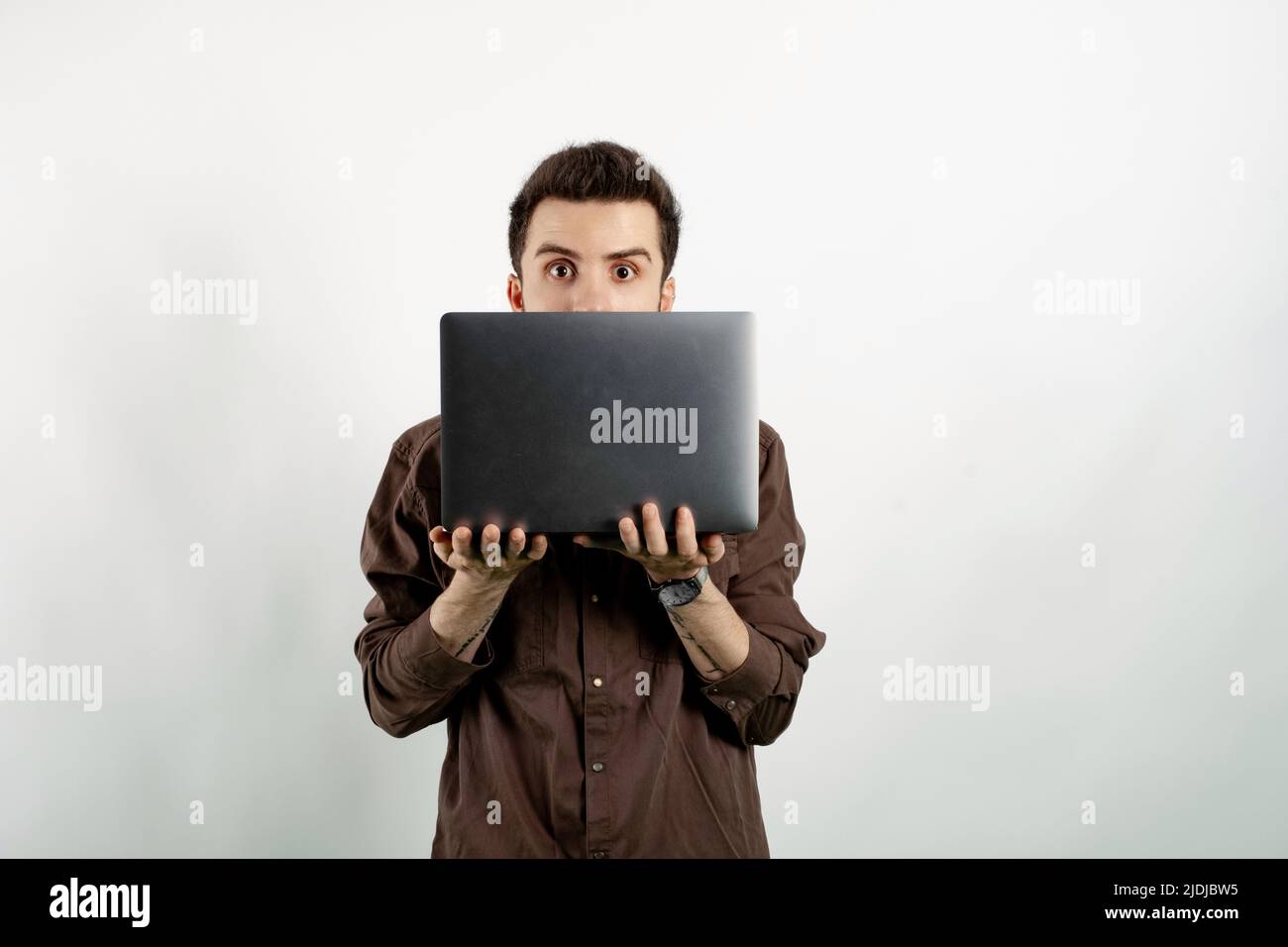 Young man wearing brown shirt posing isolated over white background ...
