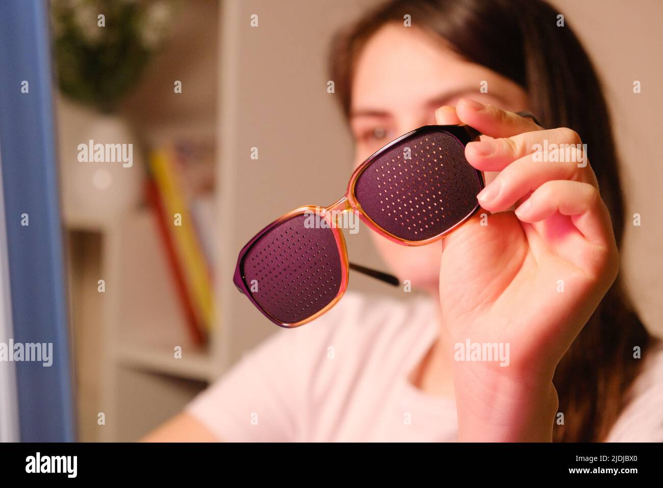 A woman in perforated glasses looks at the computer screen Stock Photo ...