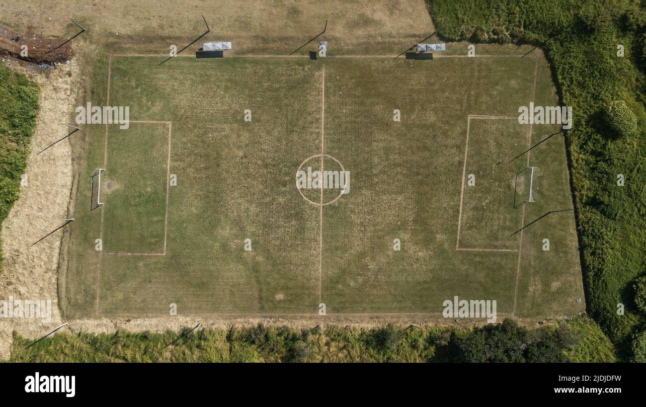 Drone view of a football field with crooked lines and weathered grass ...