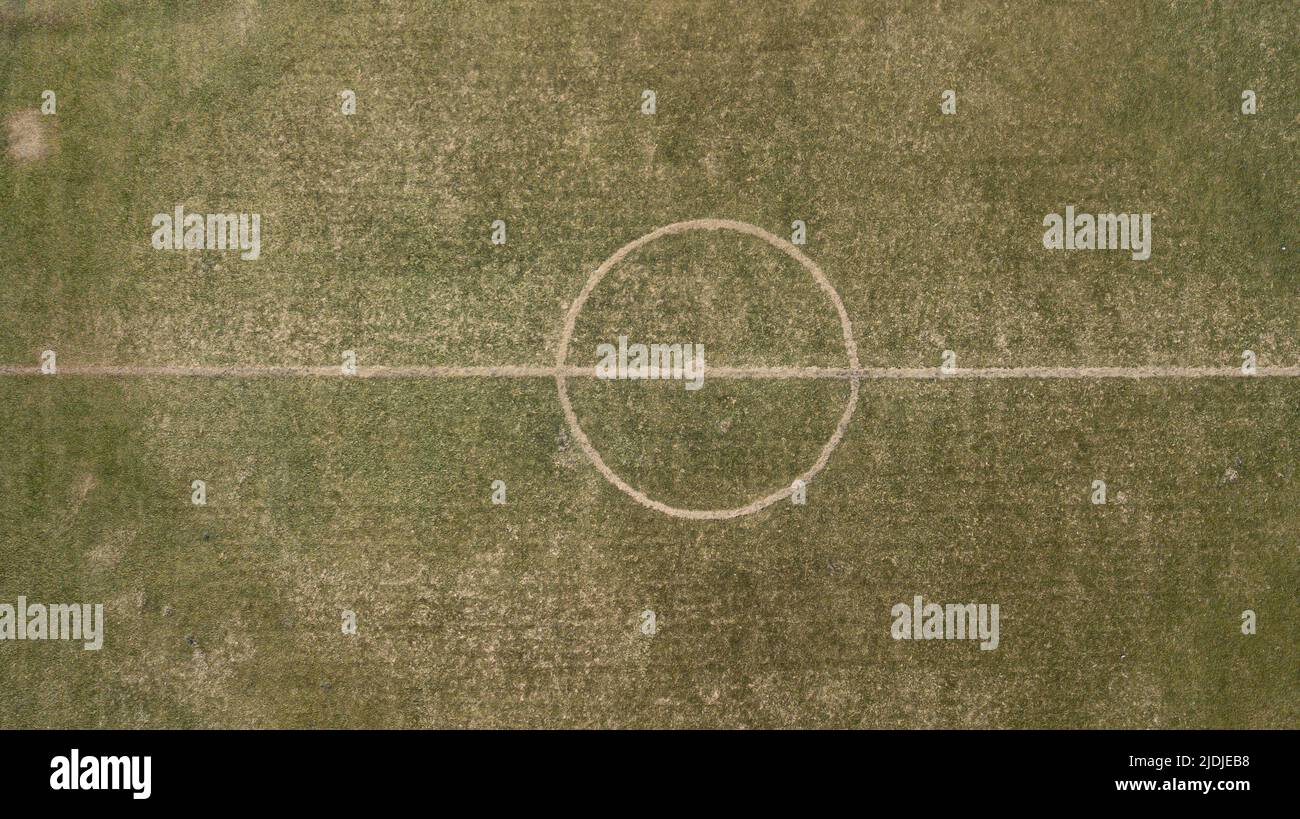 Drone view of a football field in the center circle, with crooked lines ...