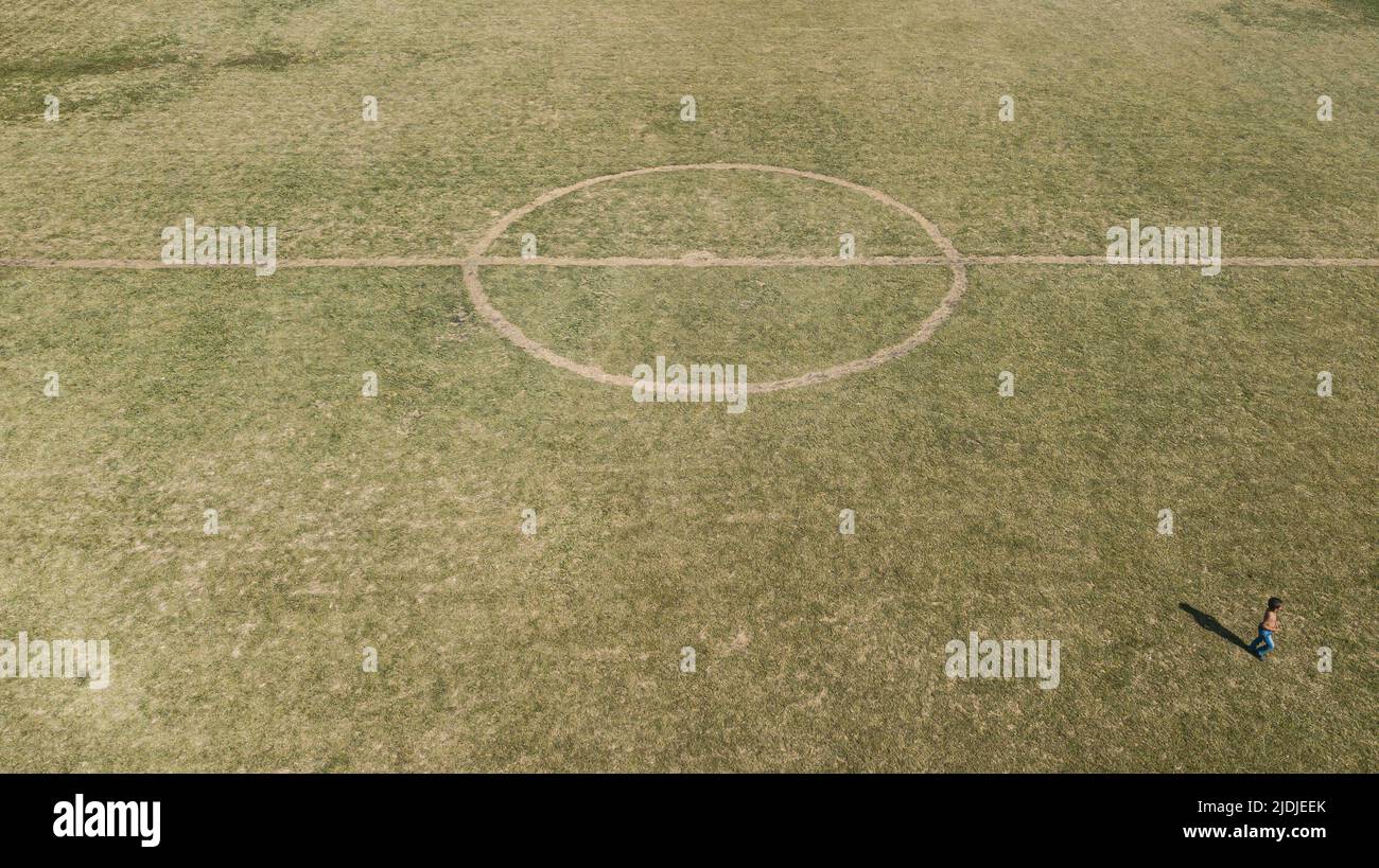 Drone view of a football field in the center circle, with crooked lines ...