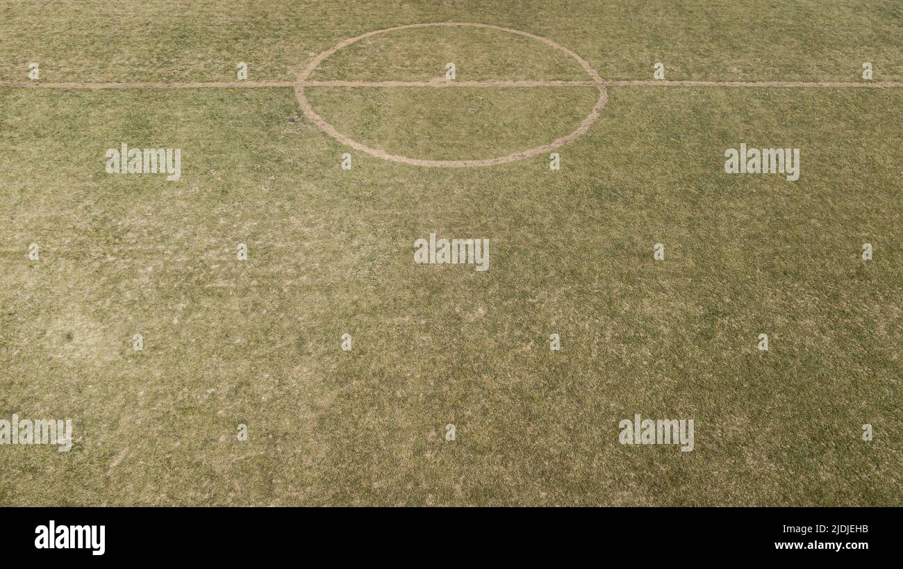 Drone view of a football field in the center circle, with crooked lines ...