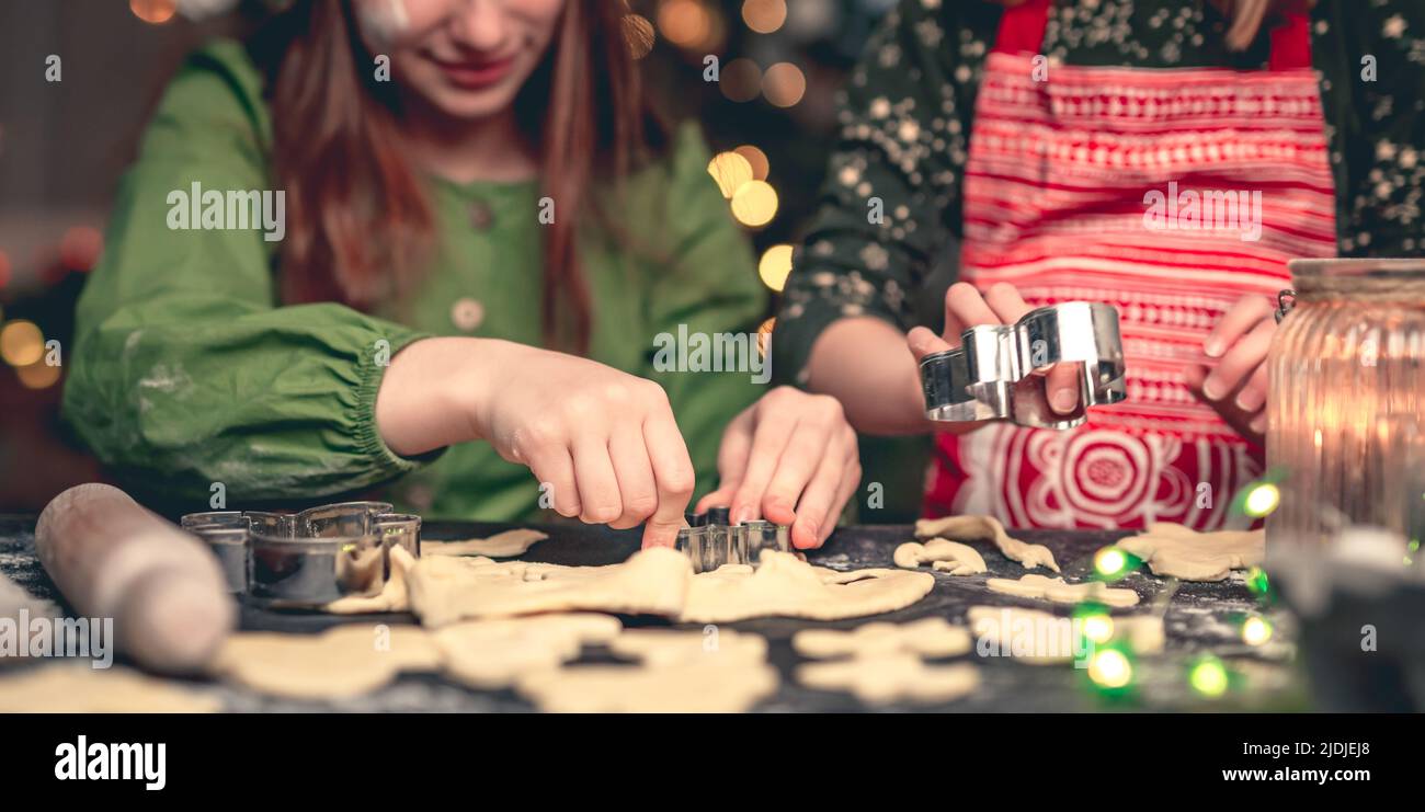 Little girls making Christmas cookies using tree forms. Closeup ...
