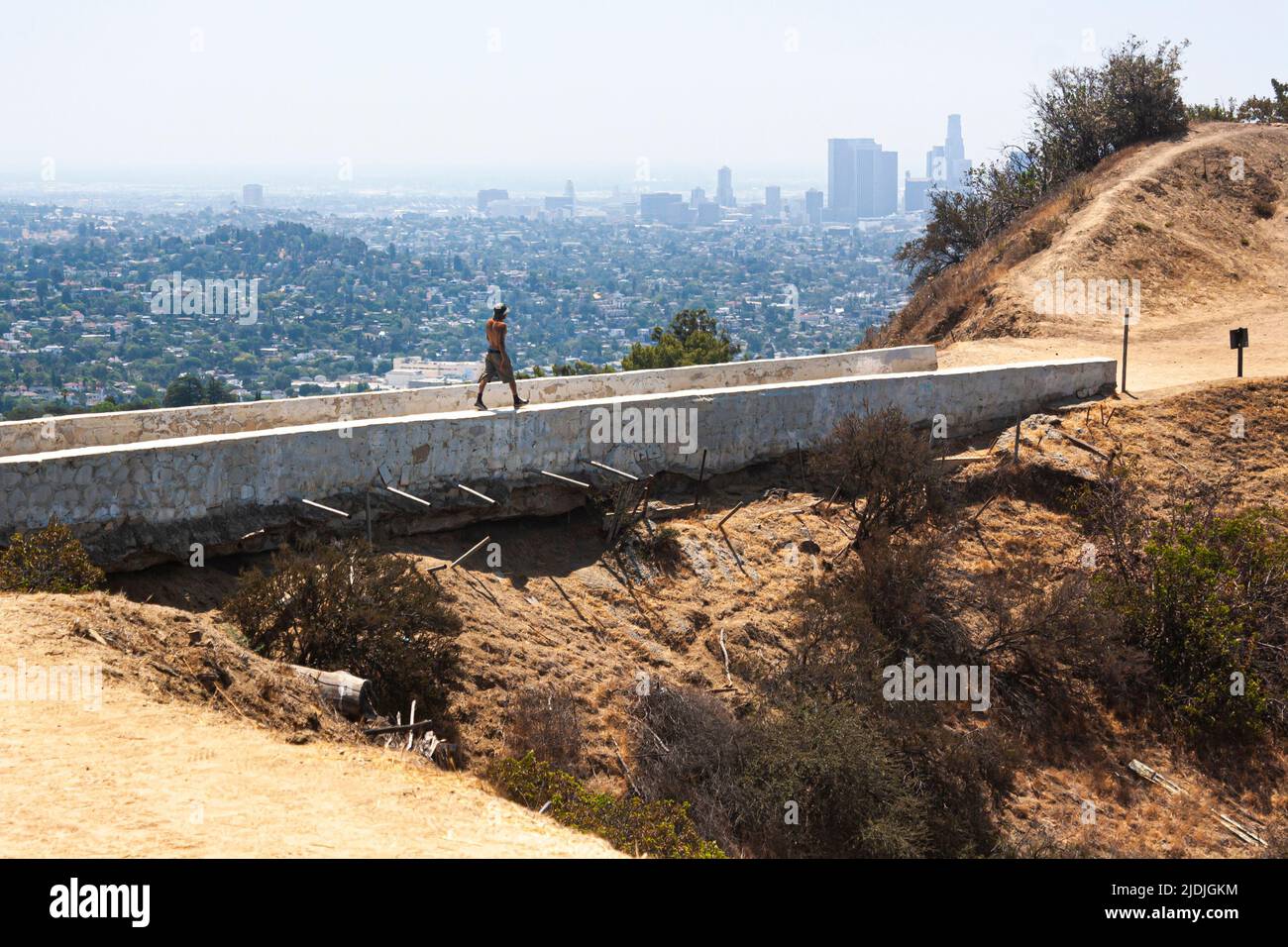 A man balancing on a wall overlooking downtown Los Angeles Stock Photo ...