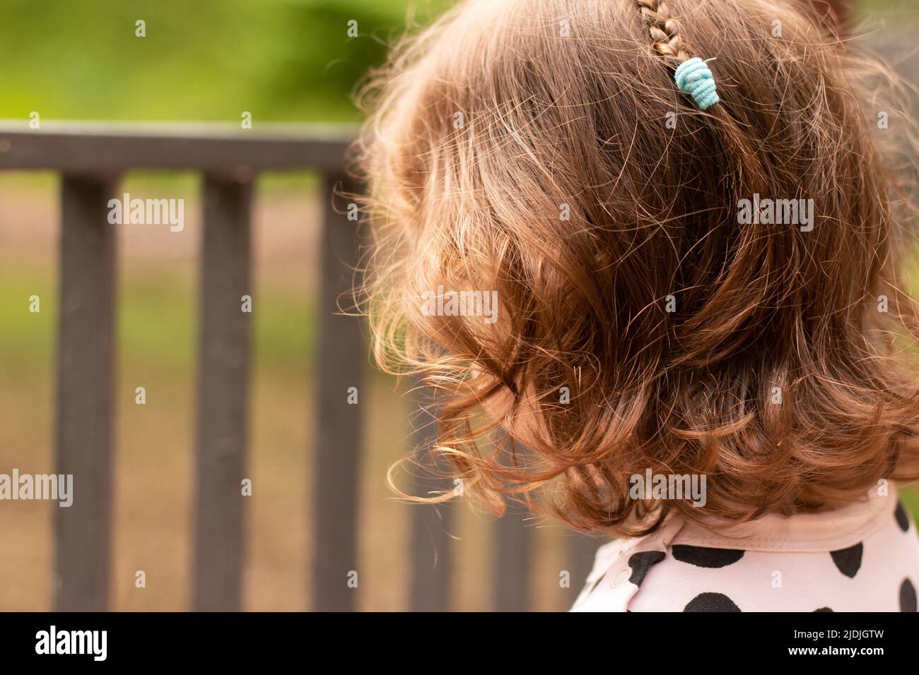 Little red-haired girl against the background of a turnstile in a ...