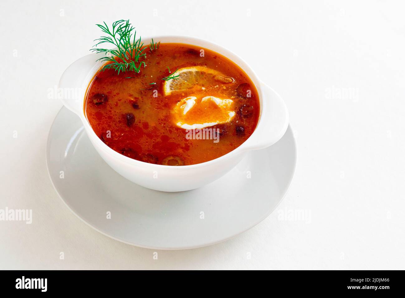 Traditional Russian meat soup Solyanka in bowl isolated on white ...