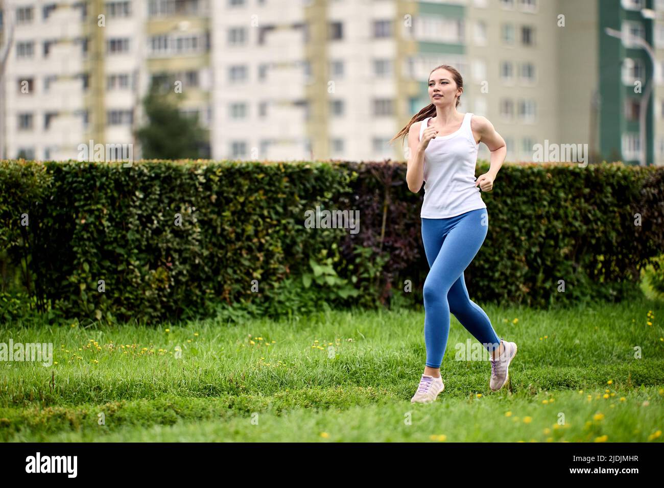 Young woman is jogging in residential area Stock Photo - Alamy