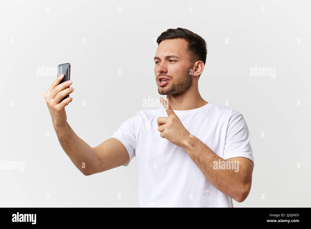 Concentrated handsome speaker influencer blogger man in basic t-shirt ...