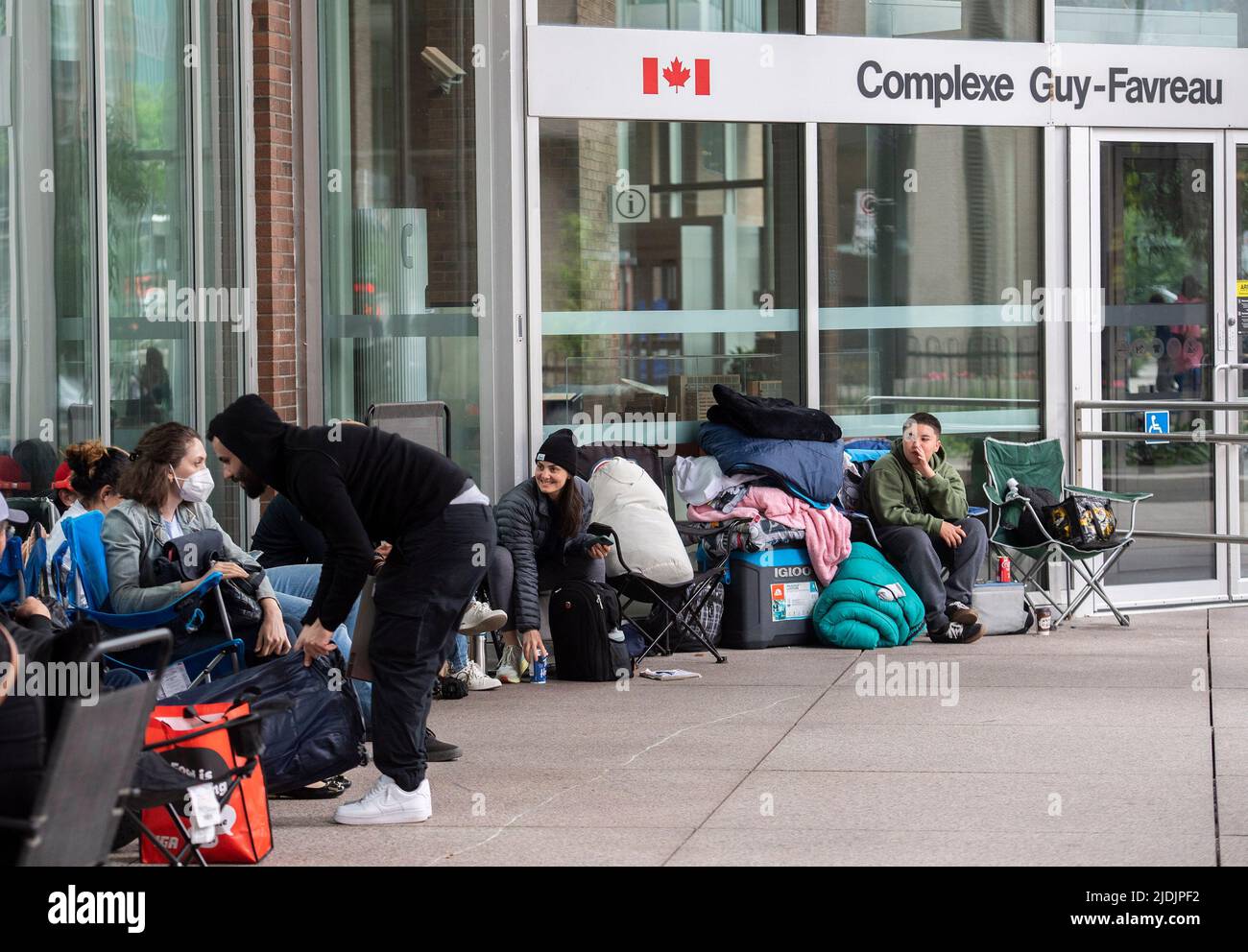 People line up outside the Guy Favreau federal building while waiting ...