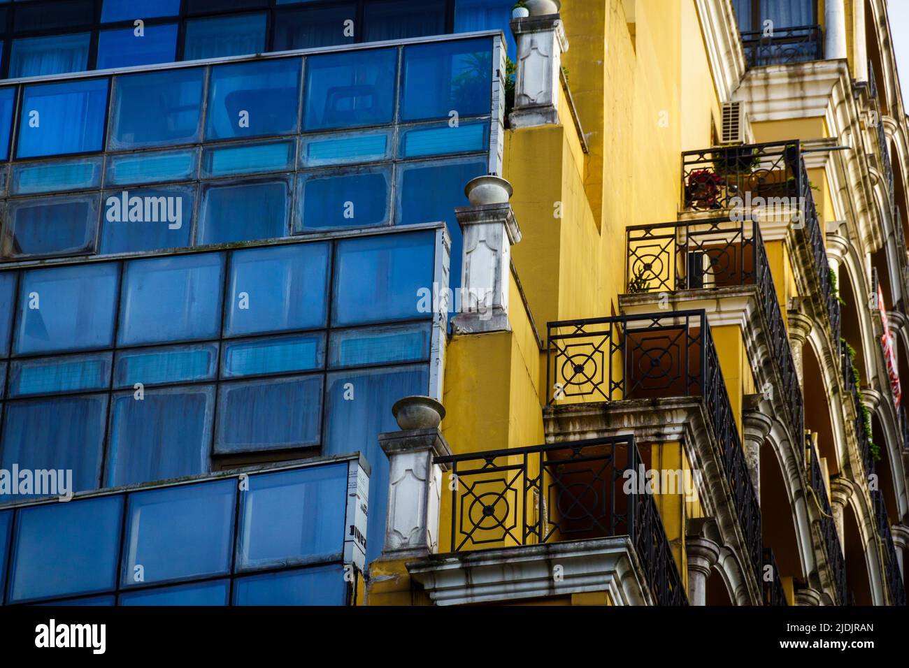 From below of stepped balconies with glass windows and metal railings ...
