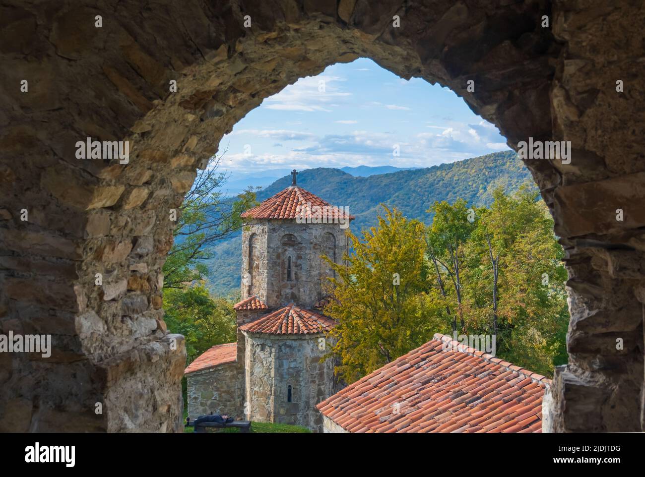 Through aged stone arch of ancient Nekresi monastery with red tiled ...