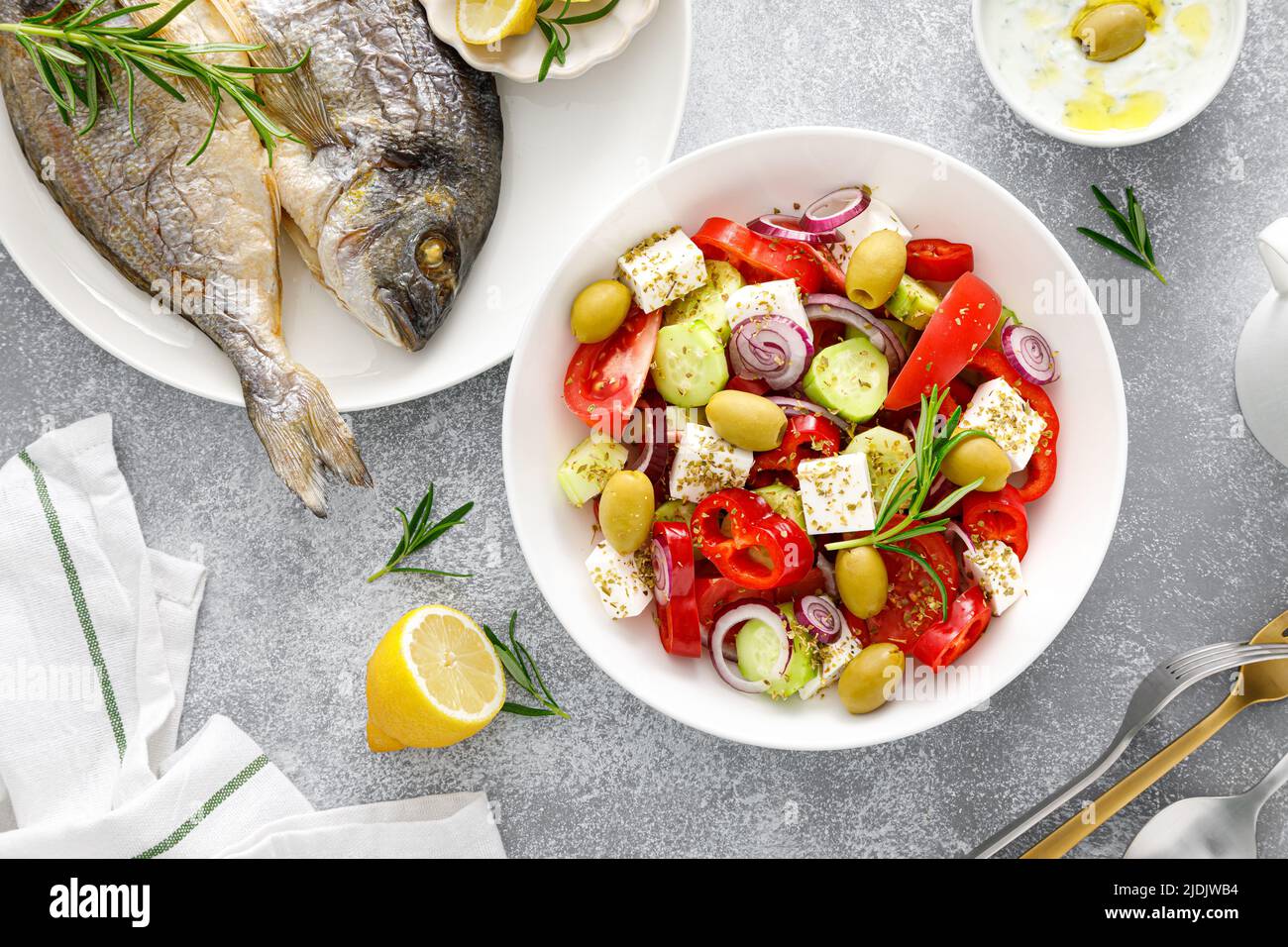 Greek salad, baked dorada fish sea bream and tzatziki dip. Healthy food ...