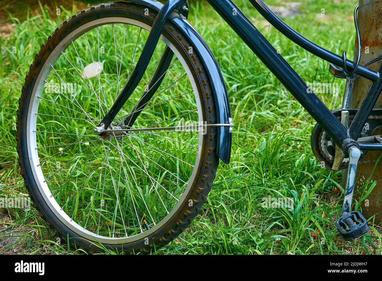 Black bike fastened to a pole. Front wheel and its frame Stock Photo ...