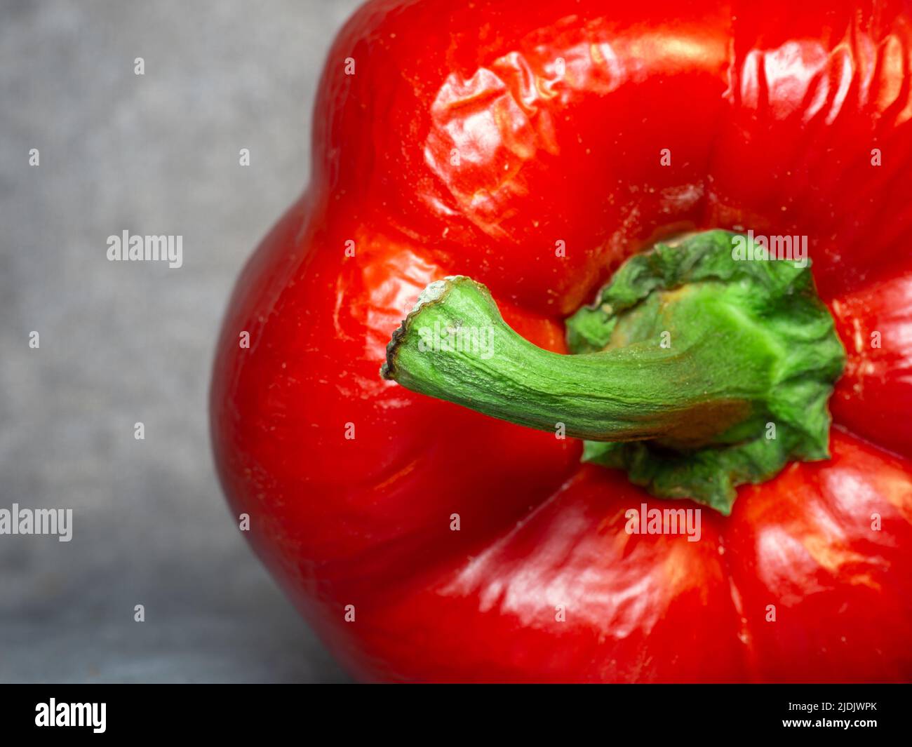Wrinkled red bell pepper on a black background. Harvest on the table ...