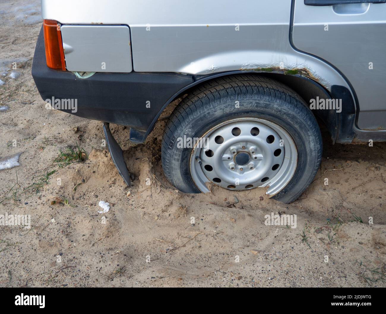 the wheel of the car is stuck in the sand. Stuck tires. Bad ecology ...