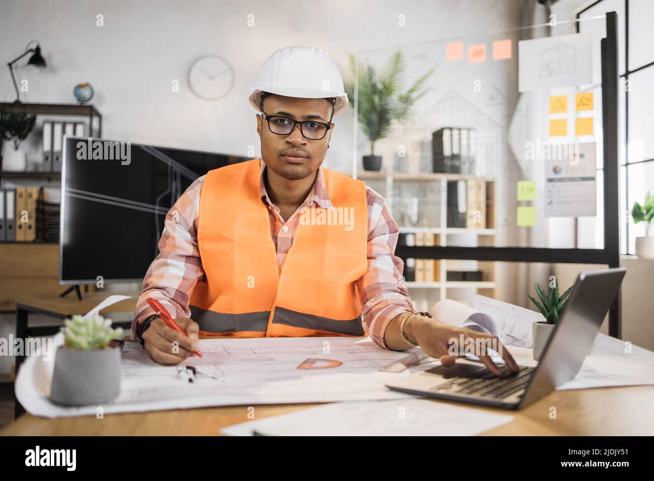Portrait of african american man wearing uniform and white hard hat at ...