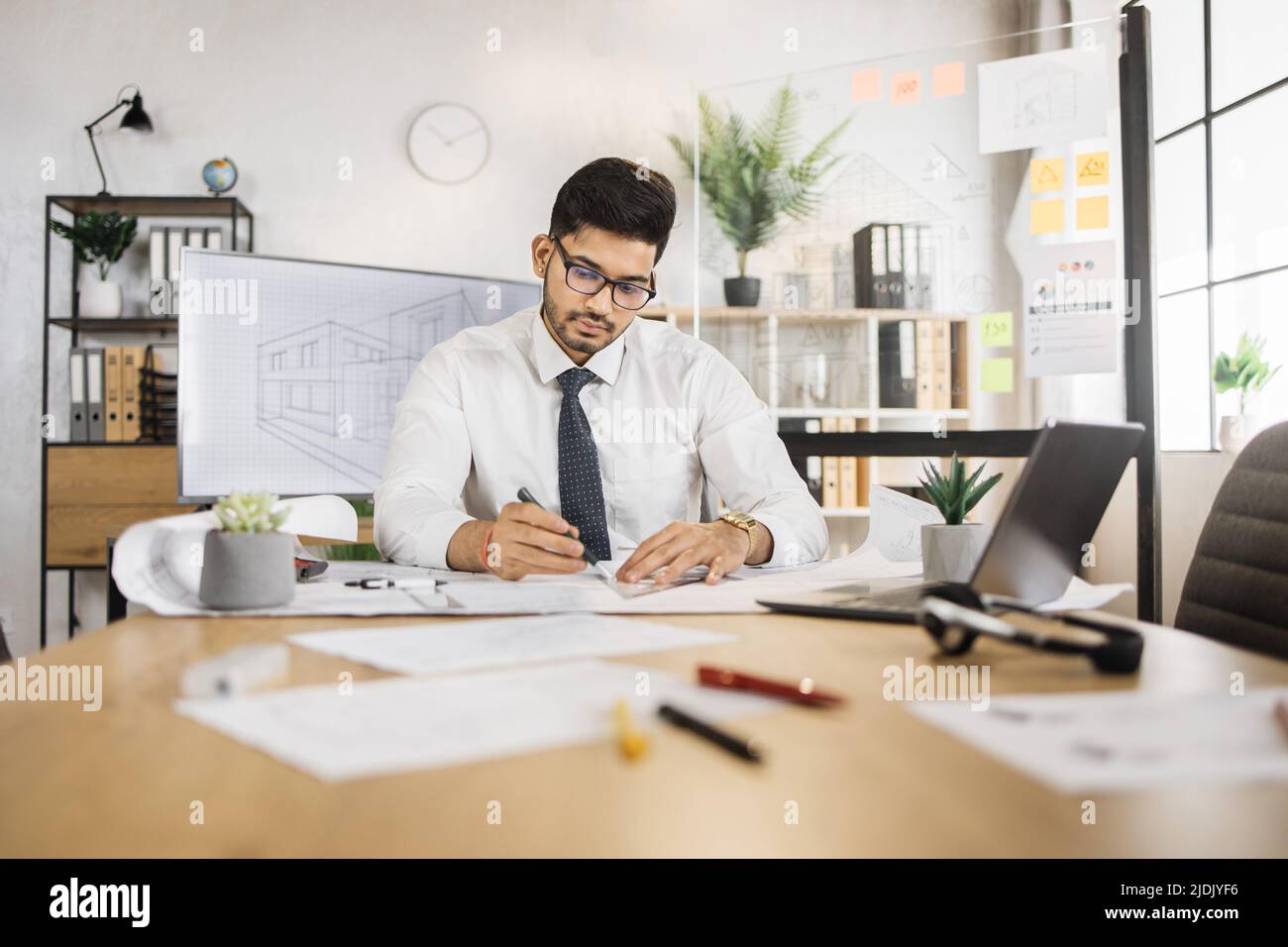 Qualified arab architect in white shirt, tie and glasses checking ...