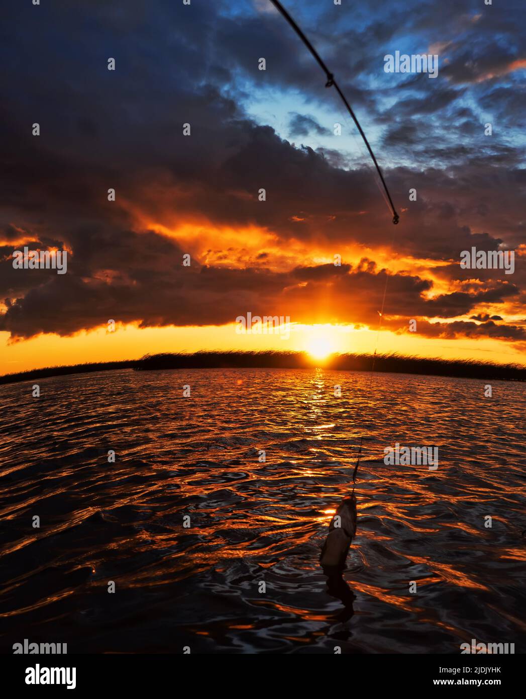 Fishing at sunset. Catching predatory fish on spinning. Sunset colors ...